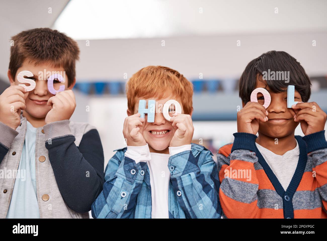 School is cool. a group of cheerful elementary school children holding ...