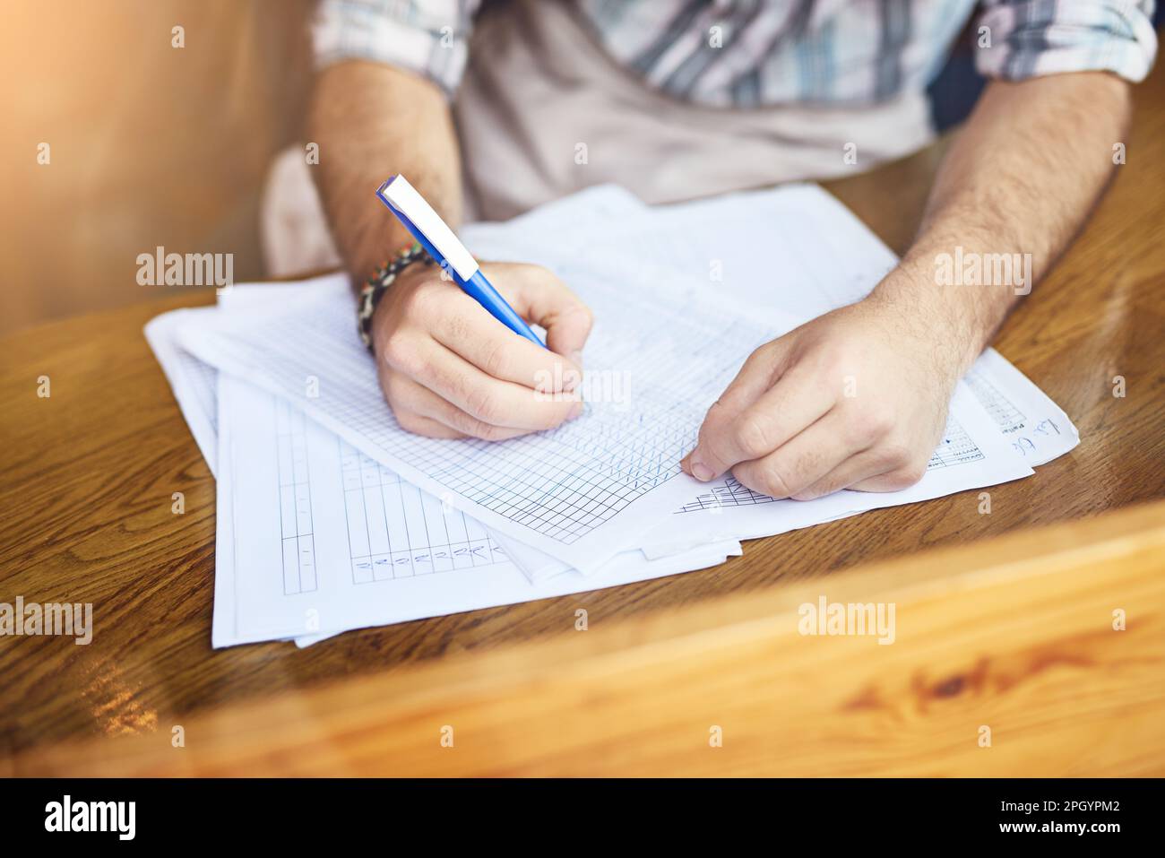 Managing his inventory. a shop owner doing some paperwork Stock Photo ...