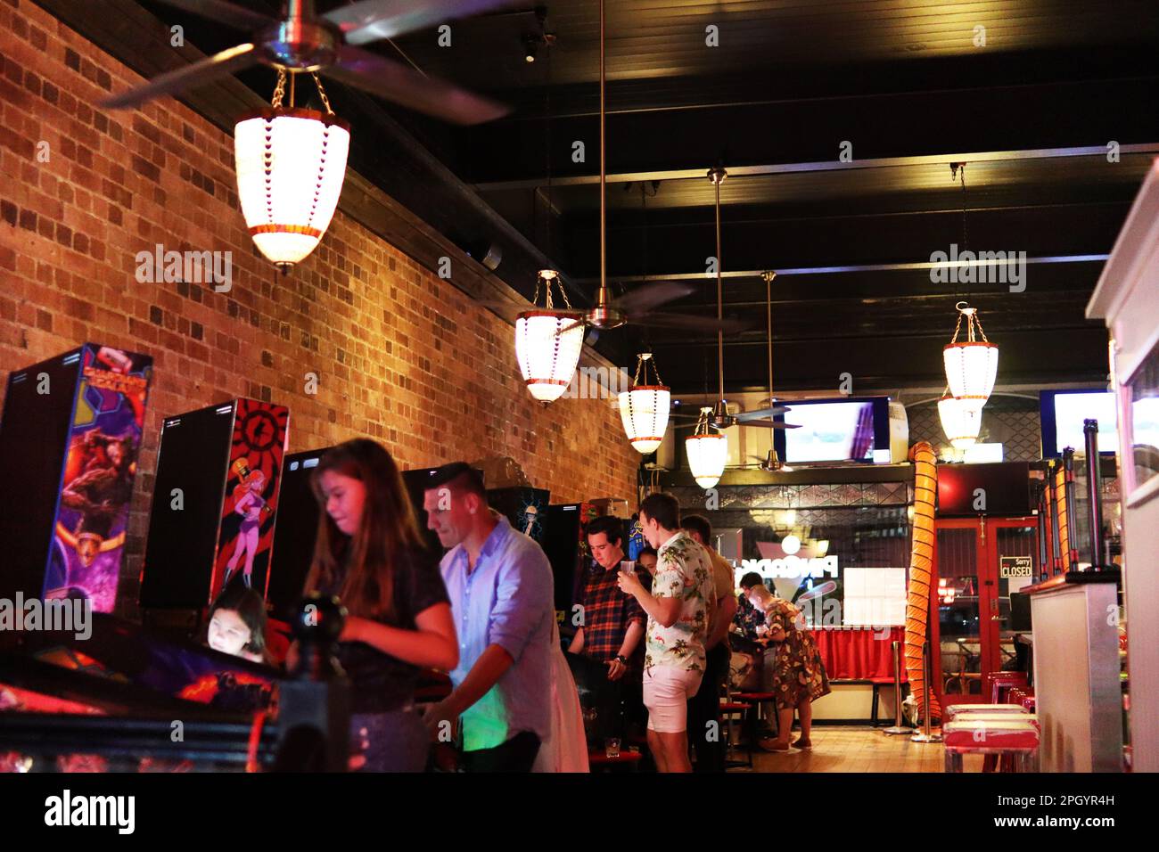 People playing arcade games on a night out in the city at a restaurant ...