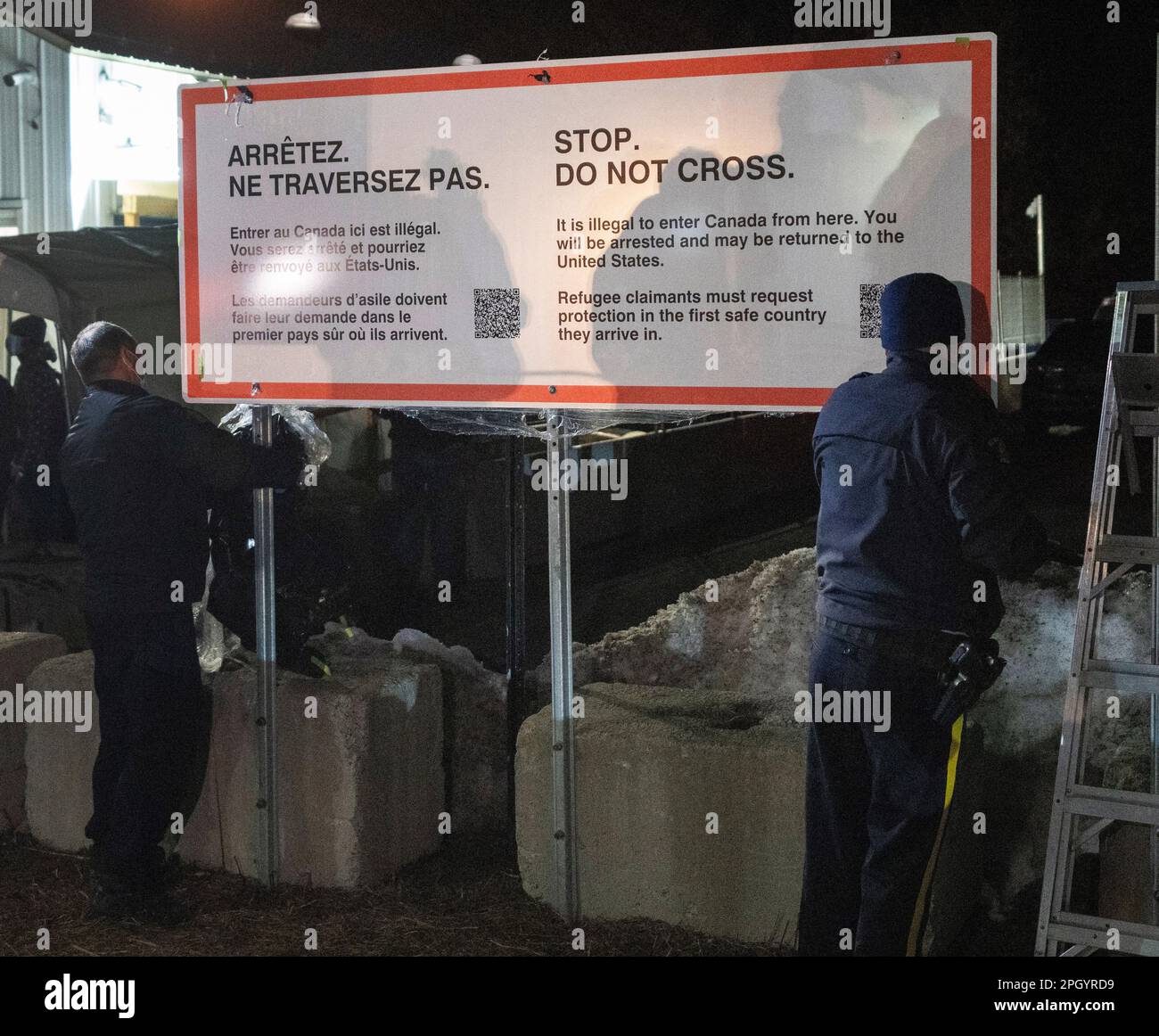 Royal Canadian Mounted Police officers unwrap a new warning sign for ...