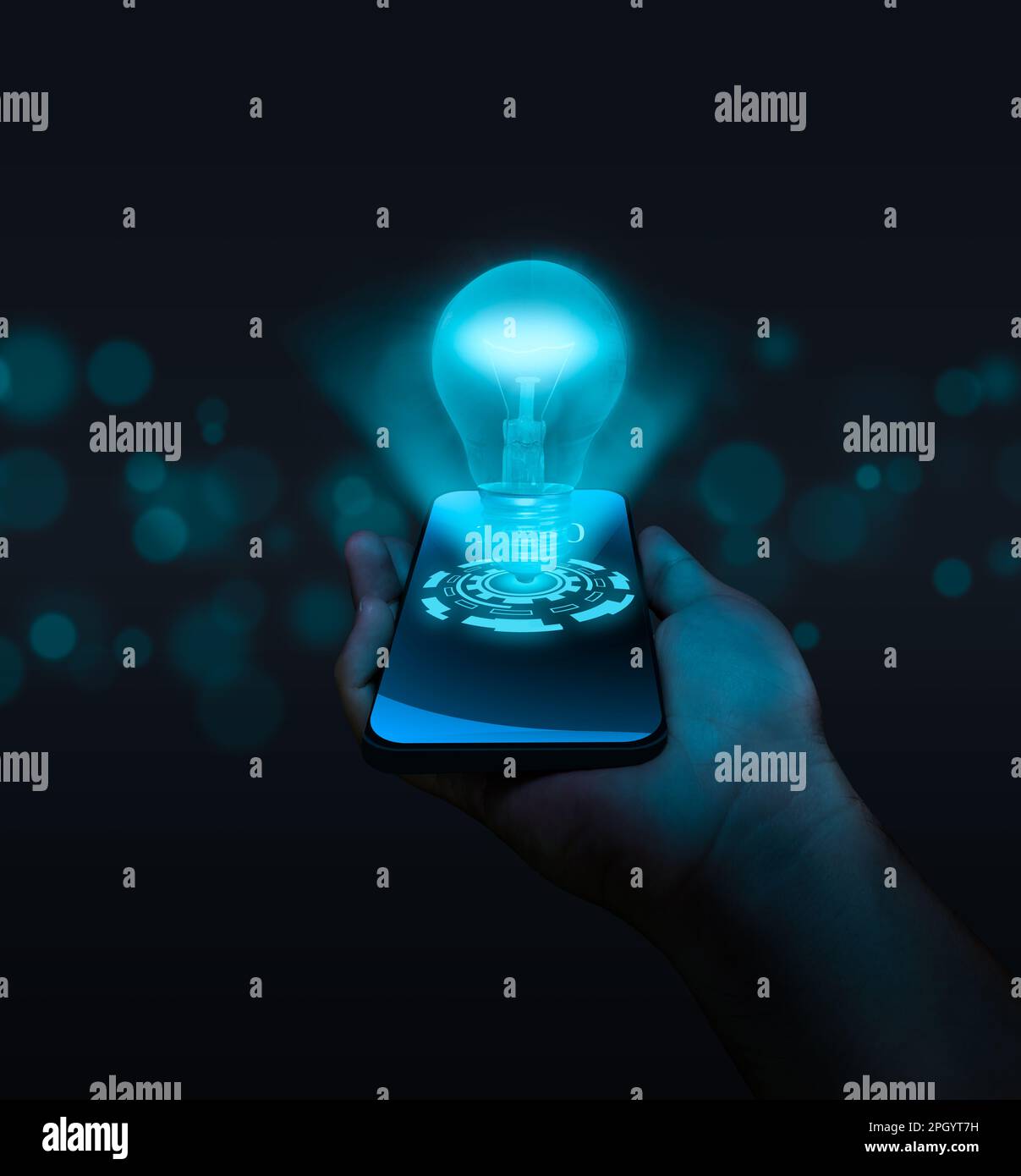 Hand holding mobile phone with glowing lightbulb on blue bokeh ...