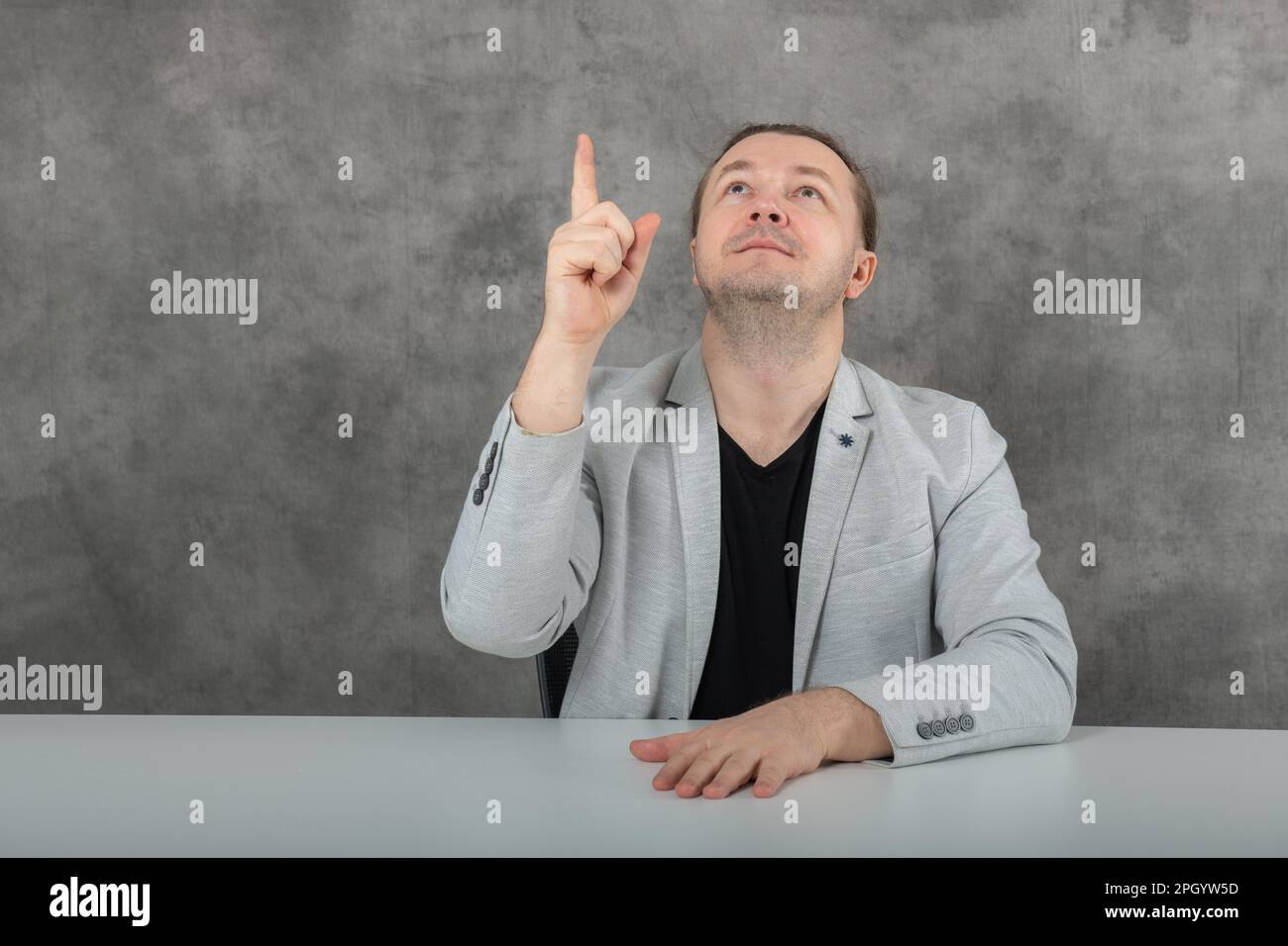 Points up one man in a gray suit Stock Photo - Alamy