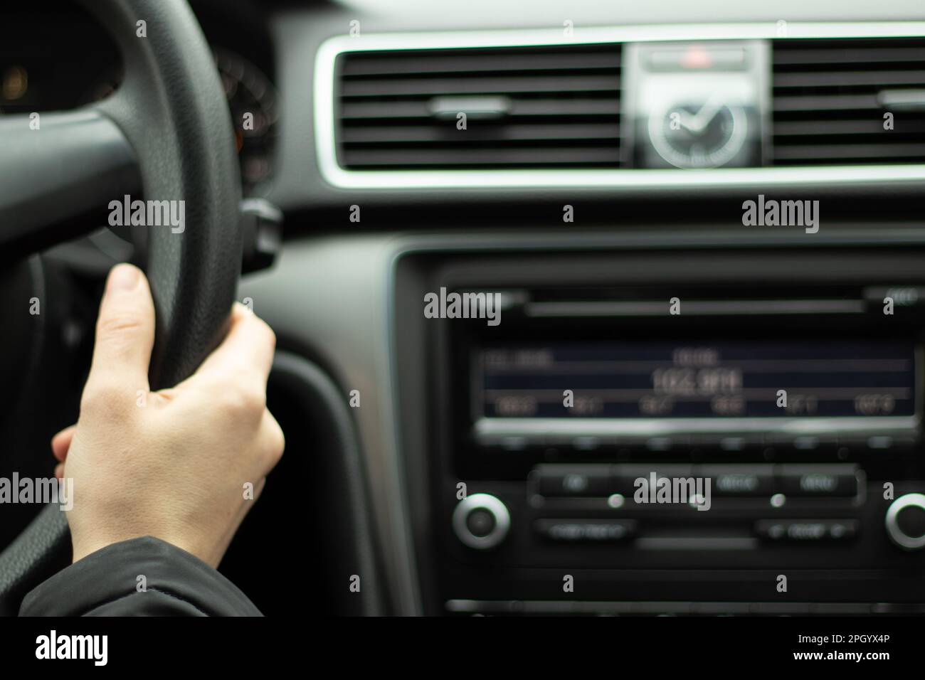 girl driving her own car in motion close-up, hands on the steering ...