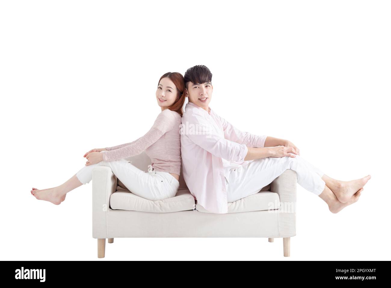Happy Young couple sitting on sofa against white background Stock Photo ...
