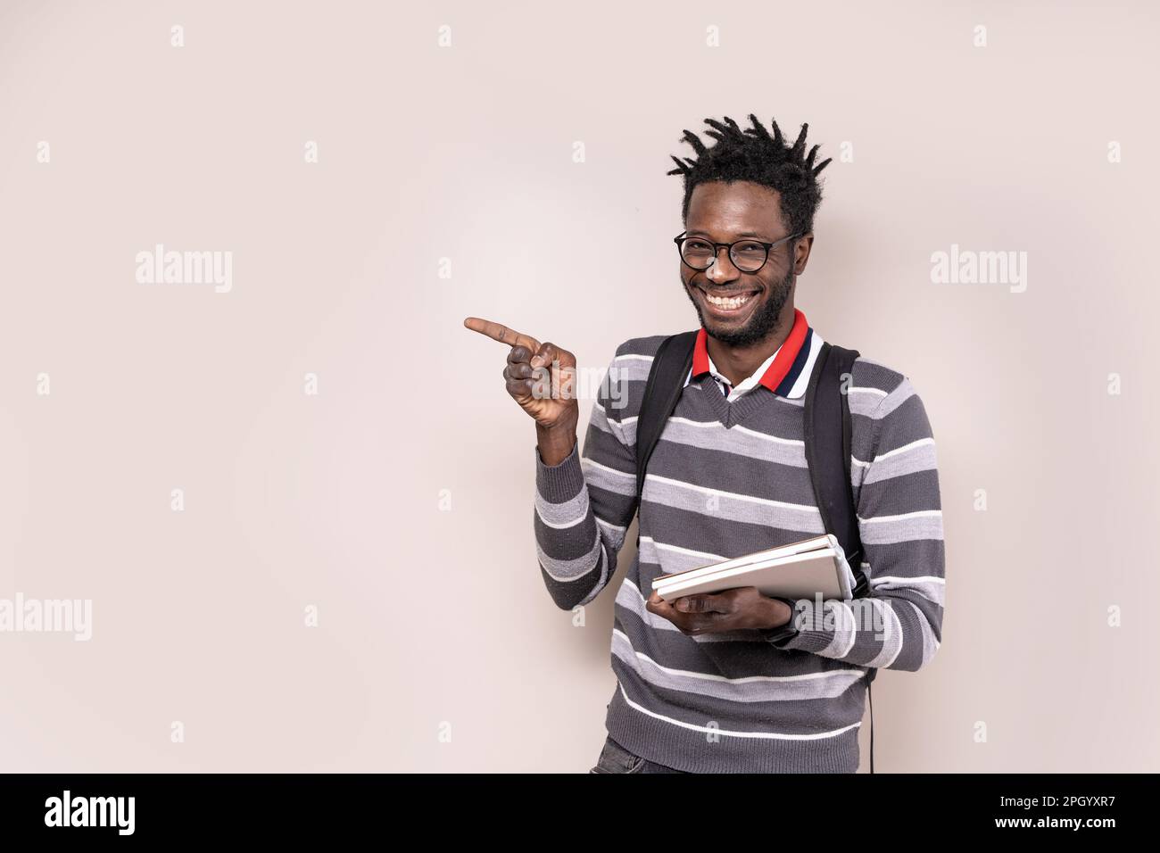 Cheerful African student wearing a striped gray sweater, and a backpack ...