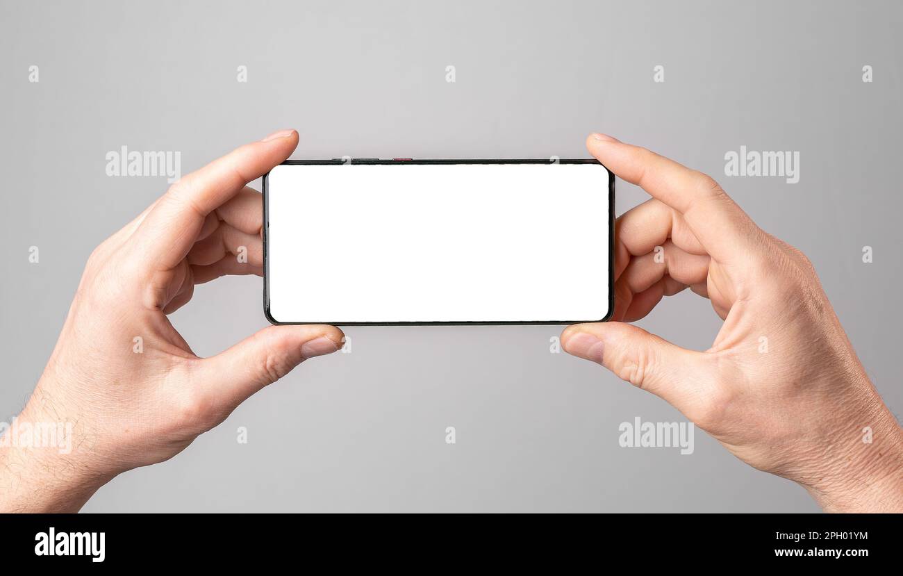 Hands hold smartphone horizontally hi-res stock photography and images ...