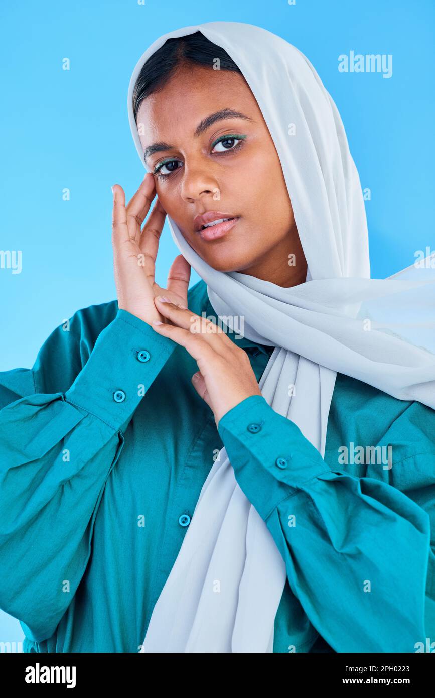 Muslim, woman and serious portrait in studio, blue background and color ...