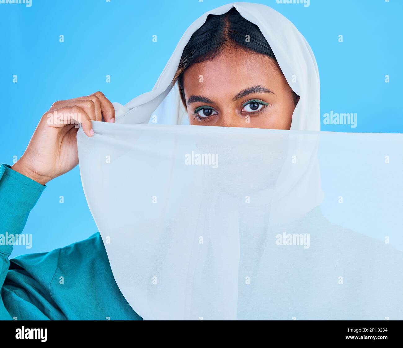 Muslim woman cover face with scarf in studio, blue background and color ...