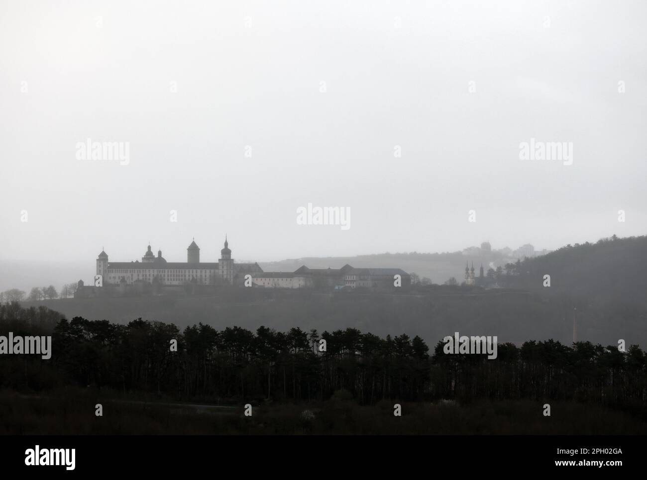 25 March 2023, Bavaria, Würzburg: Clouds cover the sky over Marienberg ...