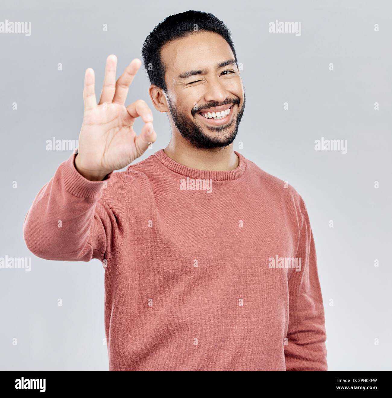 Perfect, winking and portrait of an Asian man with a hand gesture ...