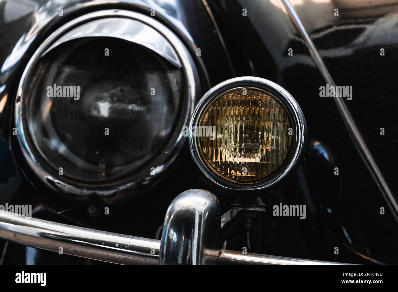 Round headlights of a vintage black car. Close up photo with soft ...