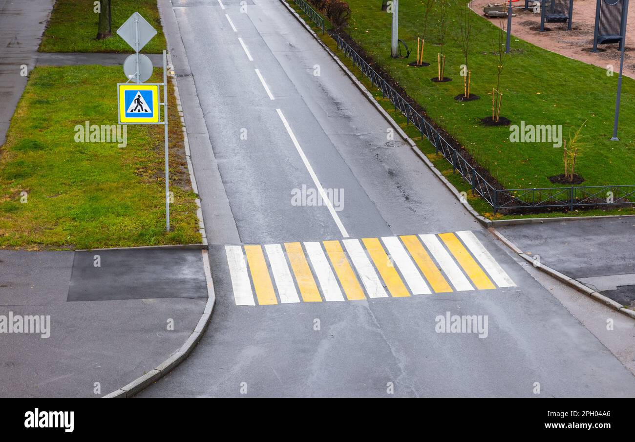Pedestrian crossing. Yellow white road marking zebra crosses an empty ...