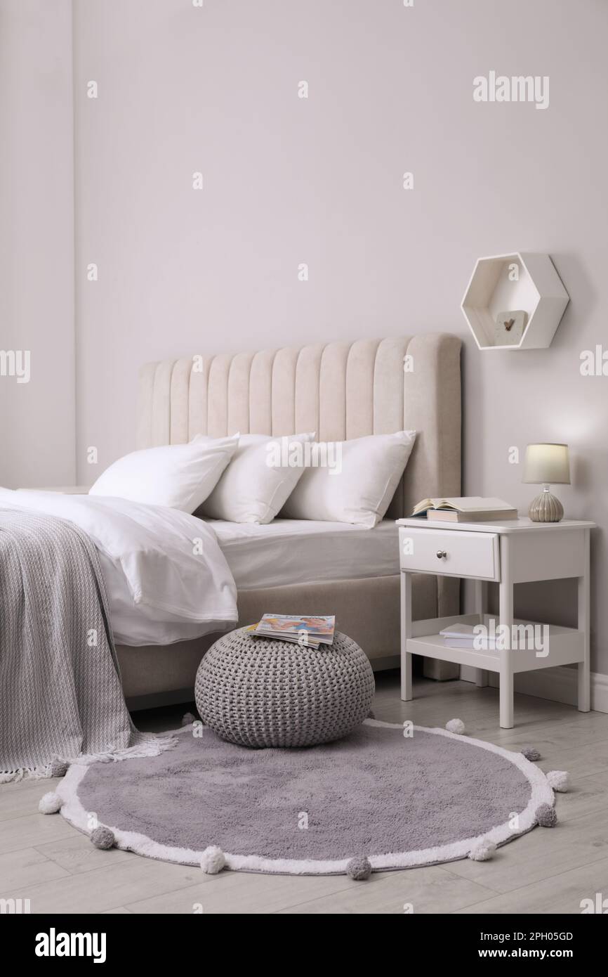 Stylish bedroom interior with knitted pouf and furniture Stock Photo ...