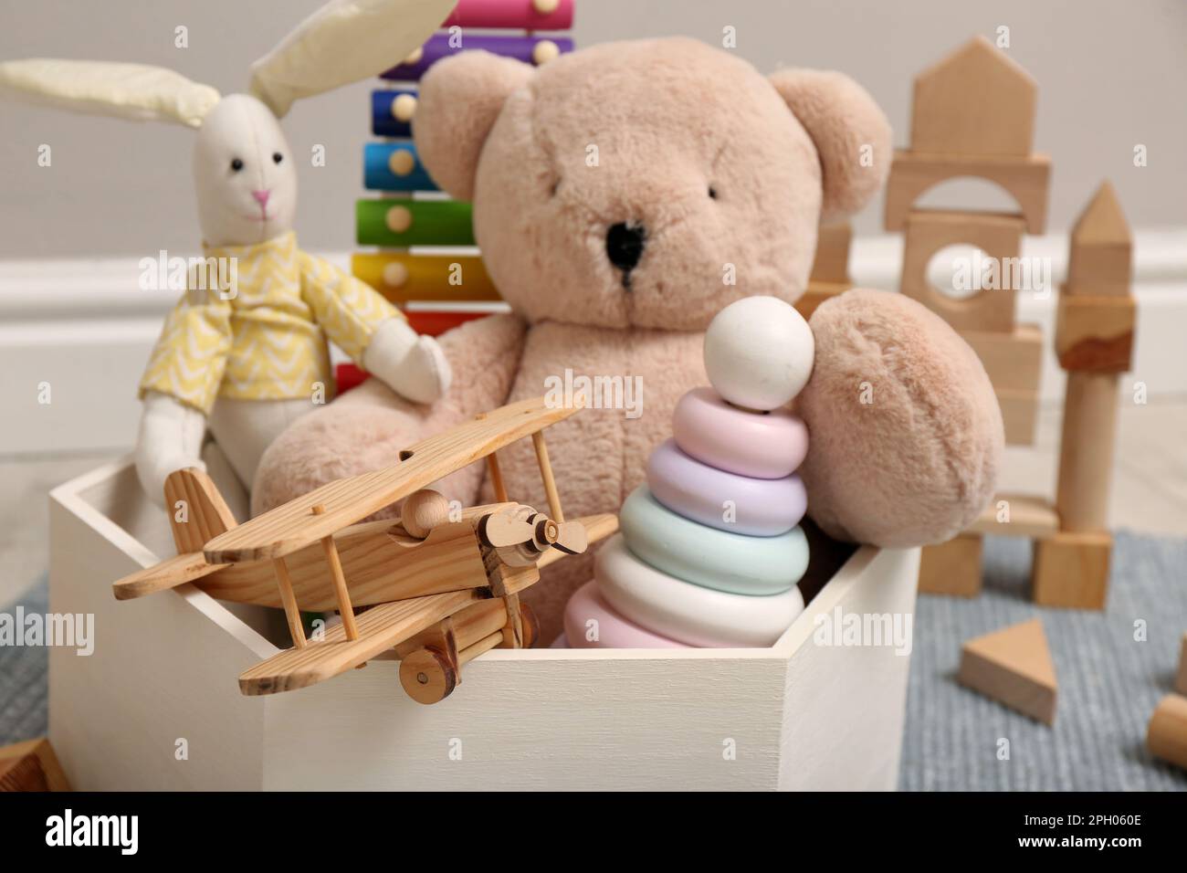 Set of different toys in box on floor, closeup Stock Photo - Alamy