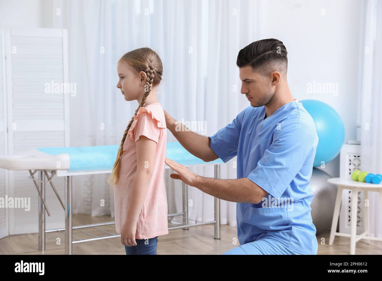 Orthopedist examining child's back in clinic. Scoliosis treatment Stock ...