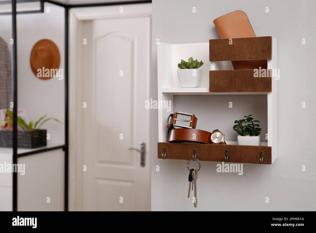 Hallway interior with stylish accessories and wooden hanger for keys on ...