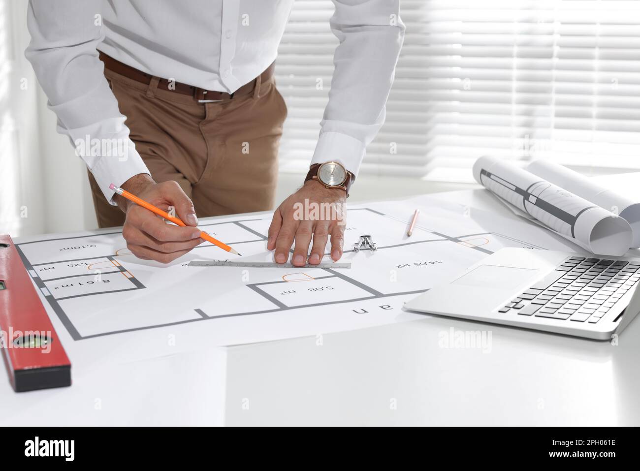 Architect working with construction drawings in office, closeup Stock ...