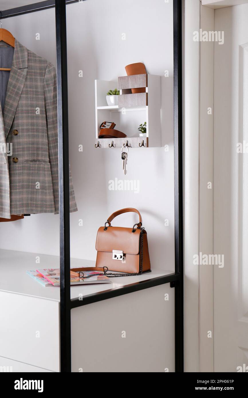 Hallway interior with stylish furniture, accessories and wooden hanger ...