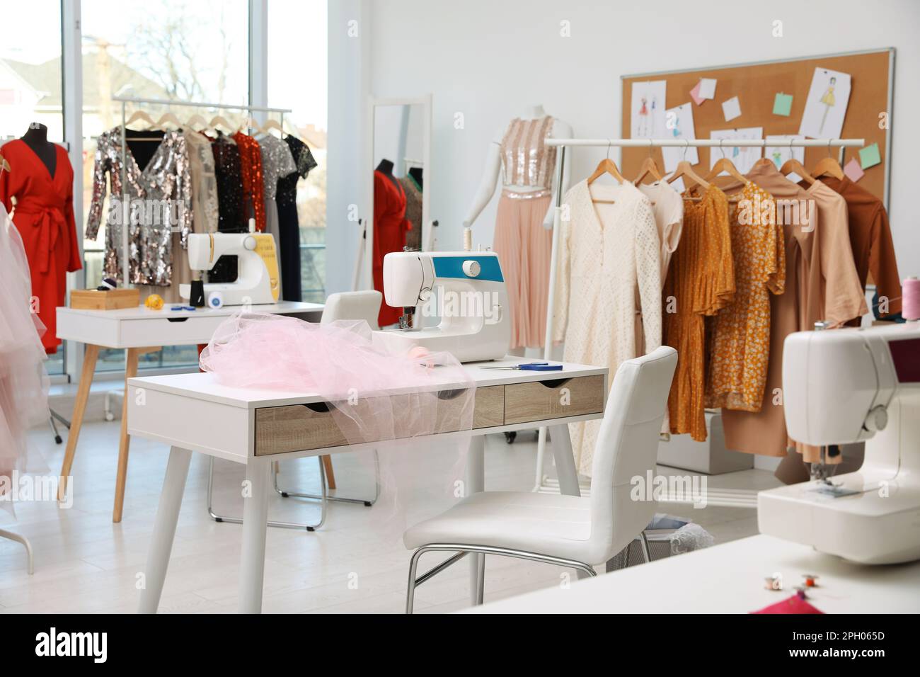 Dressmaking workshop interior with stylish female clothes and equipment ...