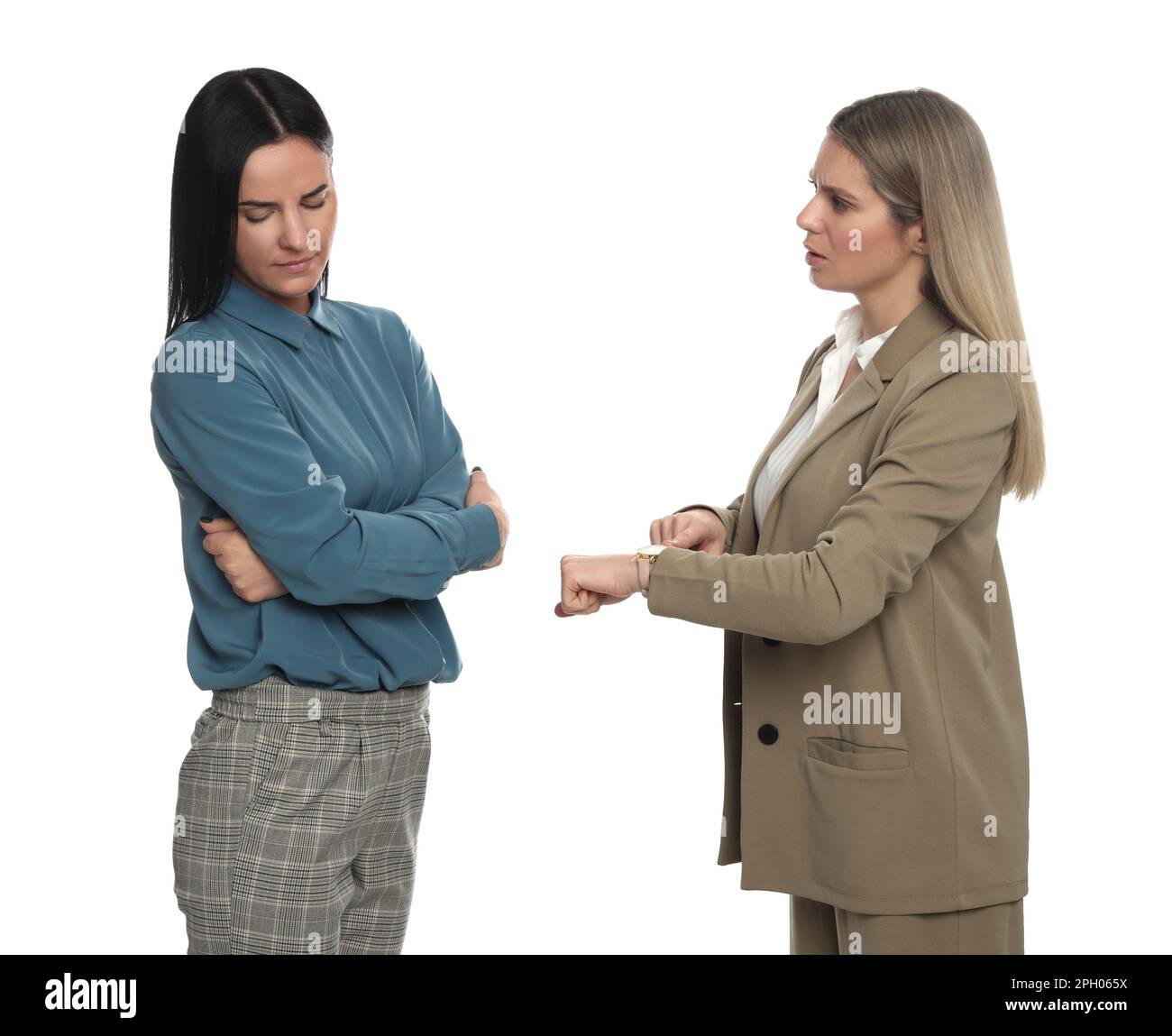 Businesswoman pointing on wrist watch while scolding employee for being ...