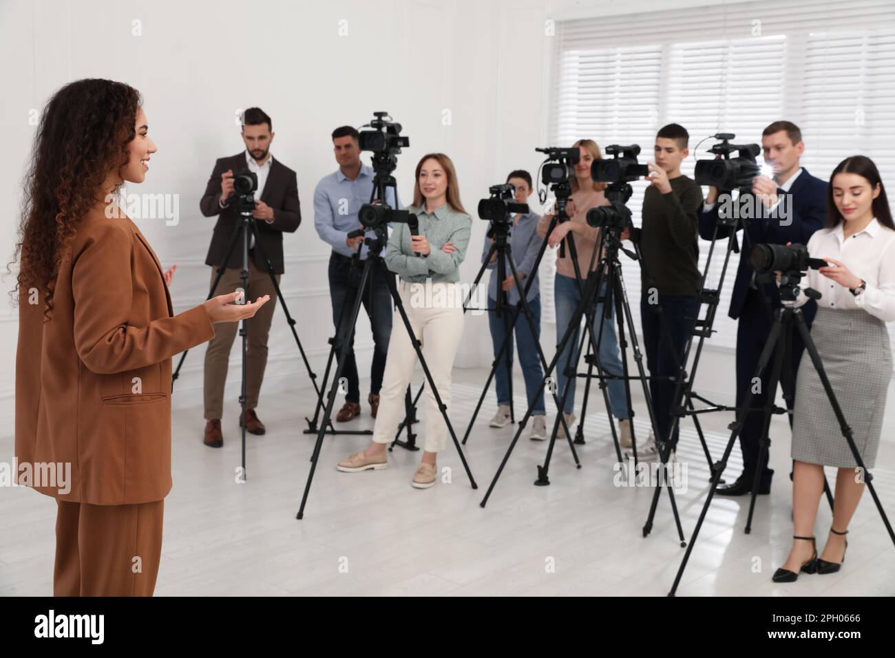 Happy African American business woman talking to group of journalists ...