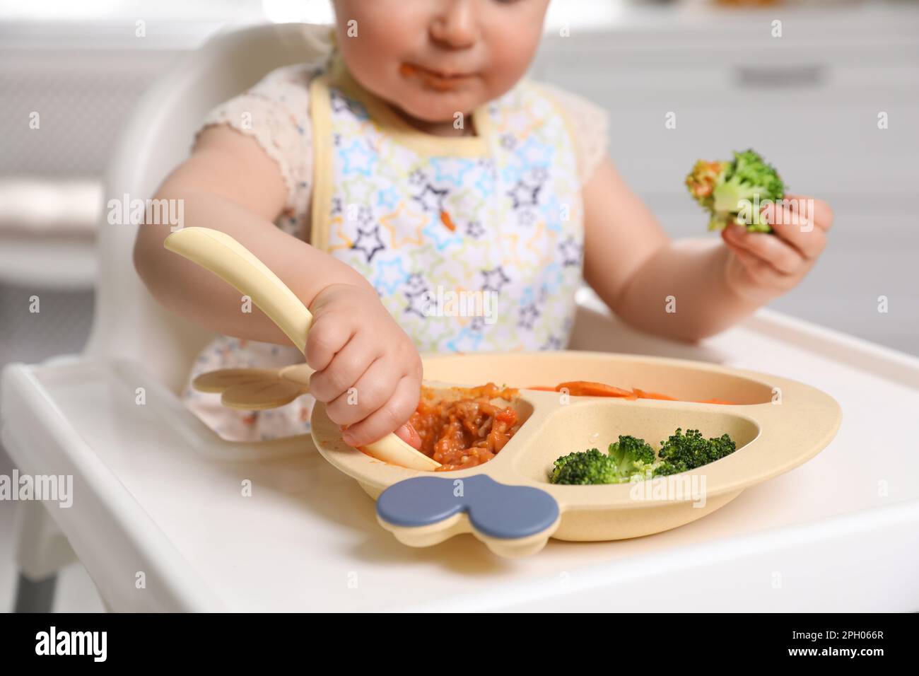 Little baby eating food in high chair, closeup Stock Photo - Alamy