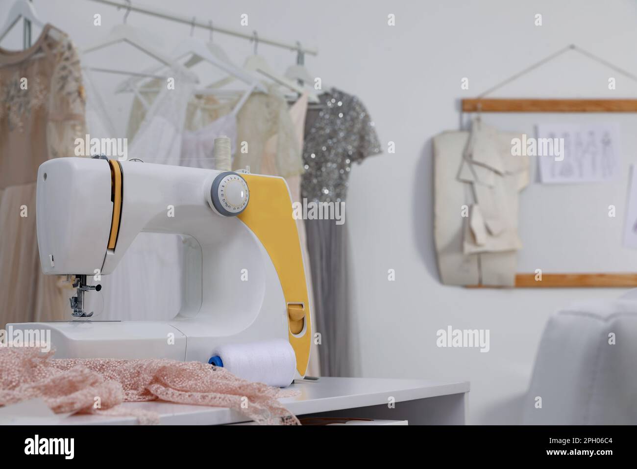 Sewing machine and fabric on table in dressmaking workshop Stock Photo ...
