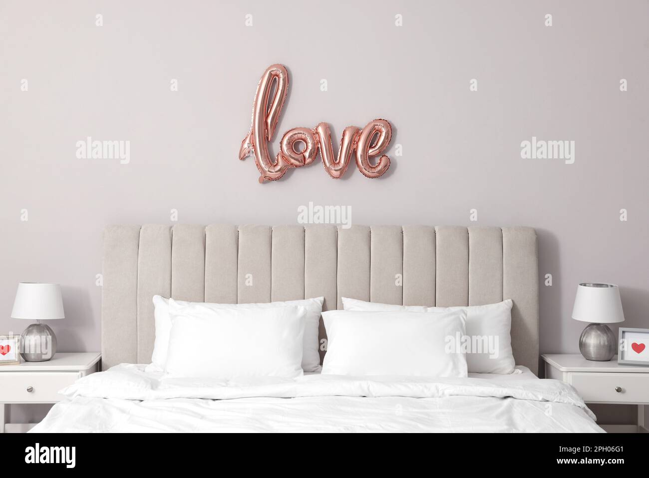 Cozy room interior with bed and balloon in shape of word Love ...