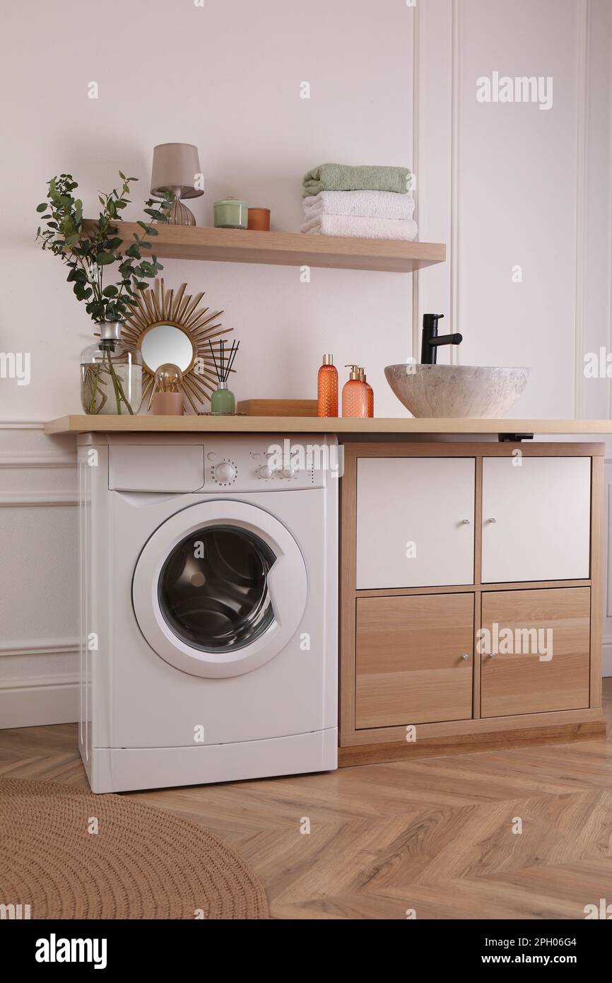 Laundry room interior with modern washing machine and stylish vessel ...