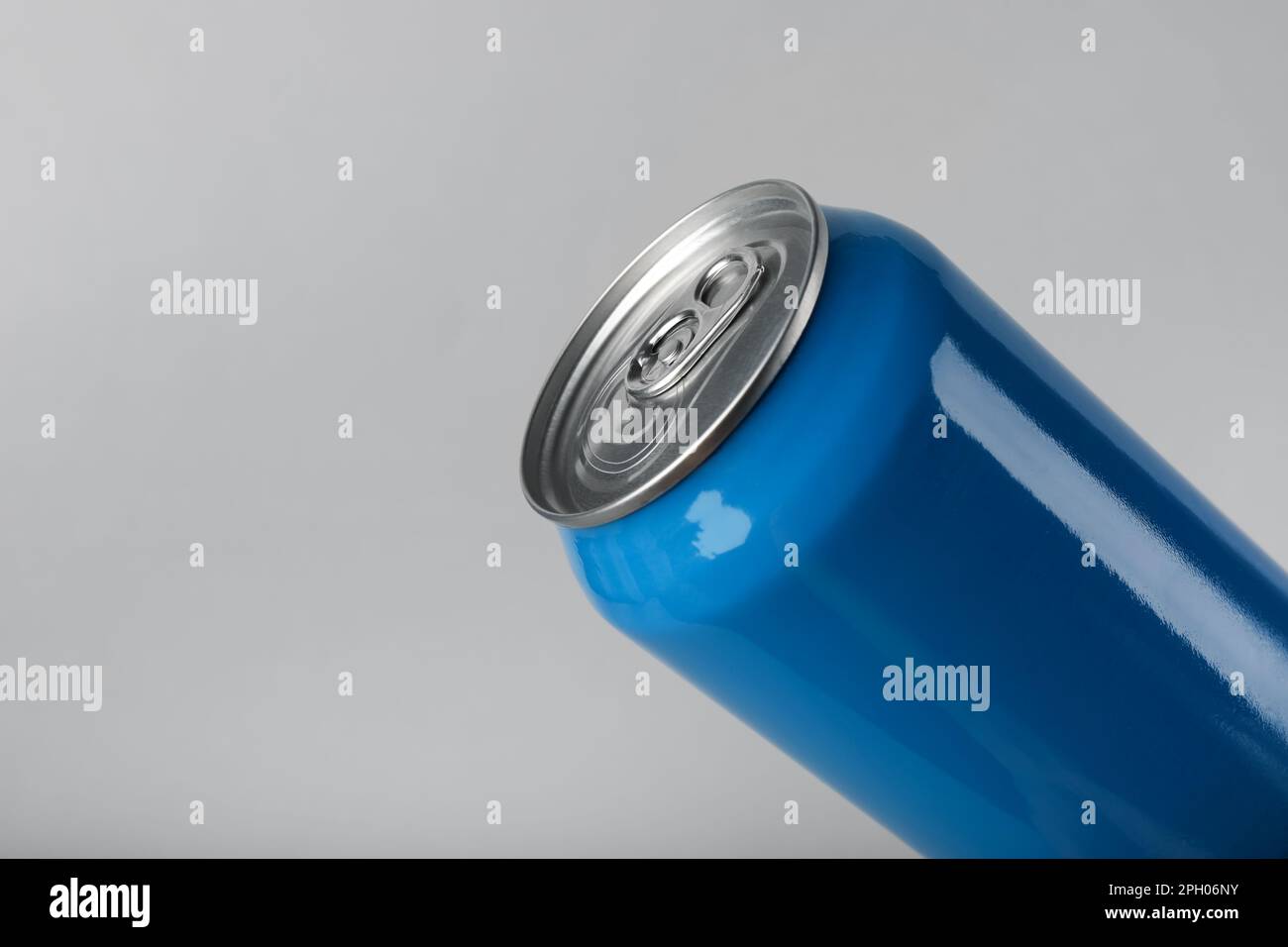 Blue can of energy drink on light grey background, closeup. Space for ...