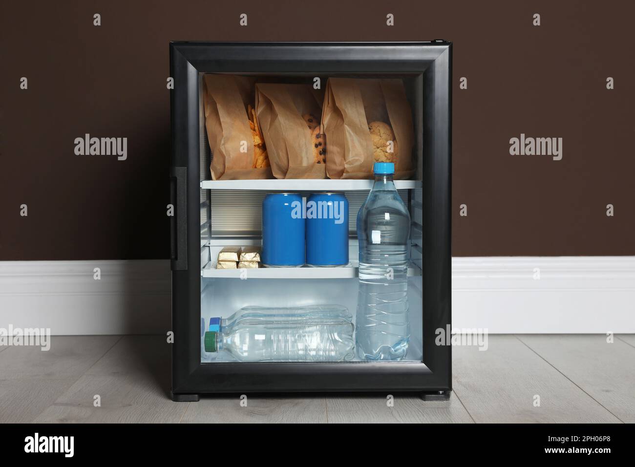 Mini bar filled with food and drinks near brown wall indoors Stock ...