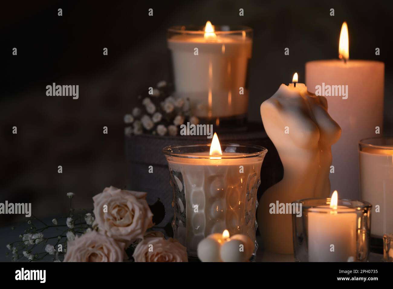 Beautiful burning candles and flowers on blurred background Stock Photo ...