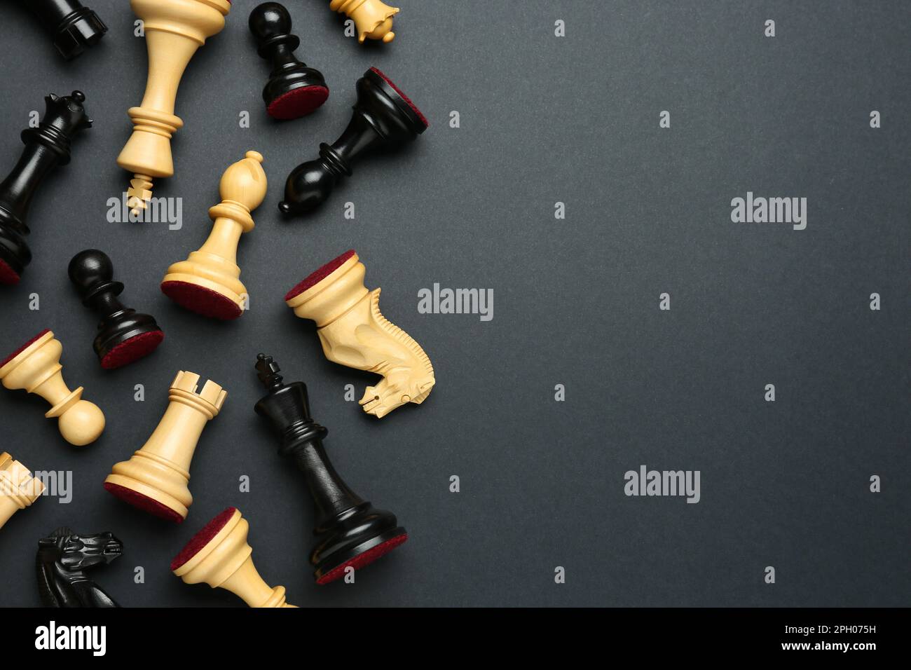 Many different chess pieces on black background, flat lay. Space for ...