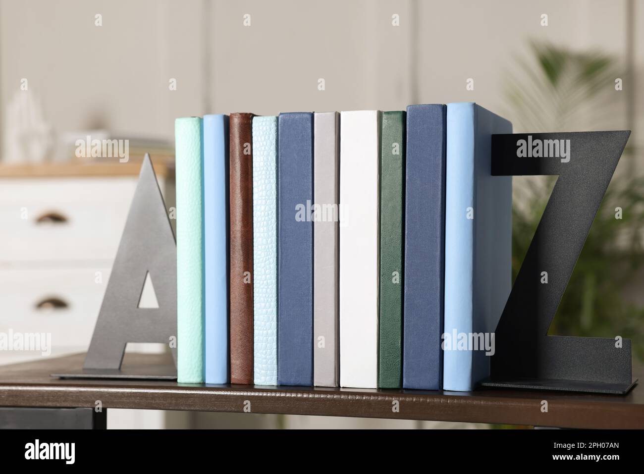 Minimalist letter bookends with books on shelf indoors Stock Photo - Alamy
