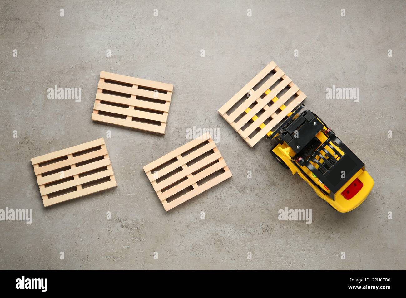 Toy forklift and wooden pallets on light grey table, flat lay Stock ...