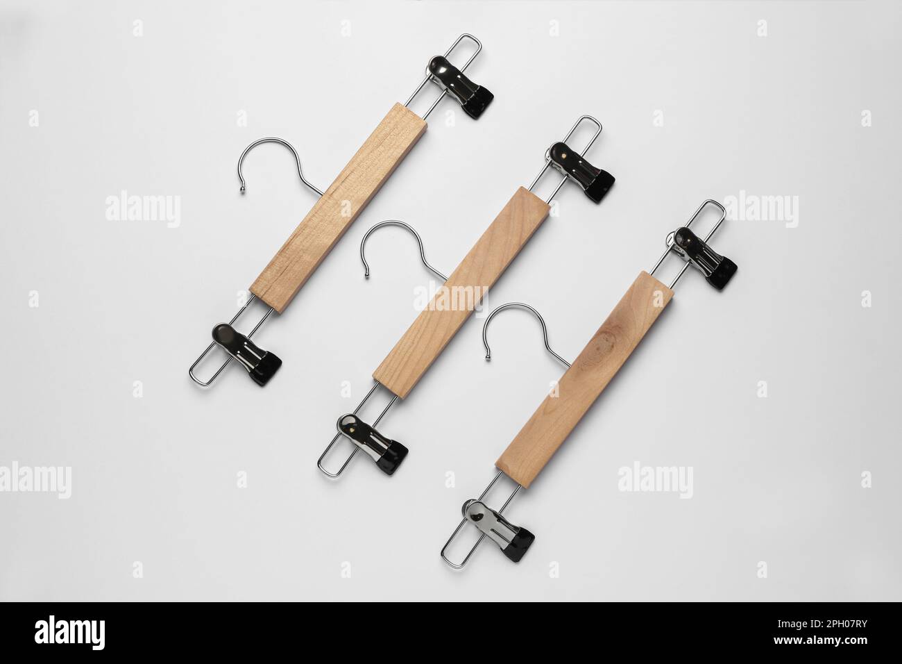 Empty wooden hangers with clips on light grey background, flat lay ...