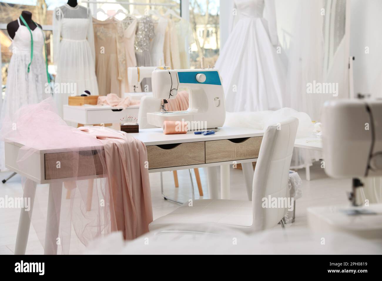 Dressmaking workshop interior with wedding dresses and equipment Stock ...