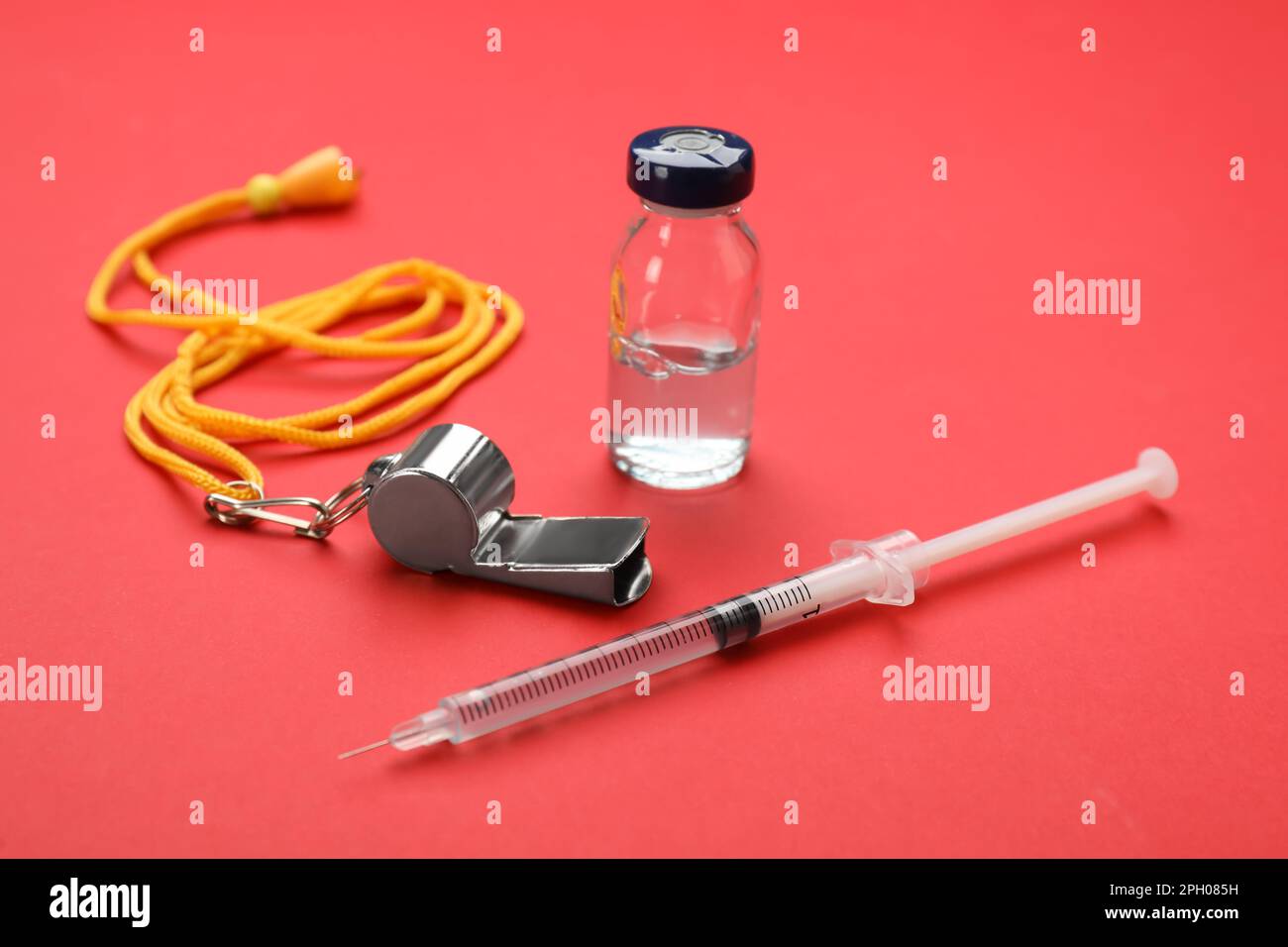 Referee whistle, syringe and vial on red background. Doping concept ...