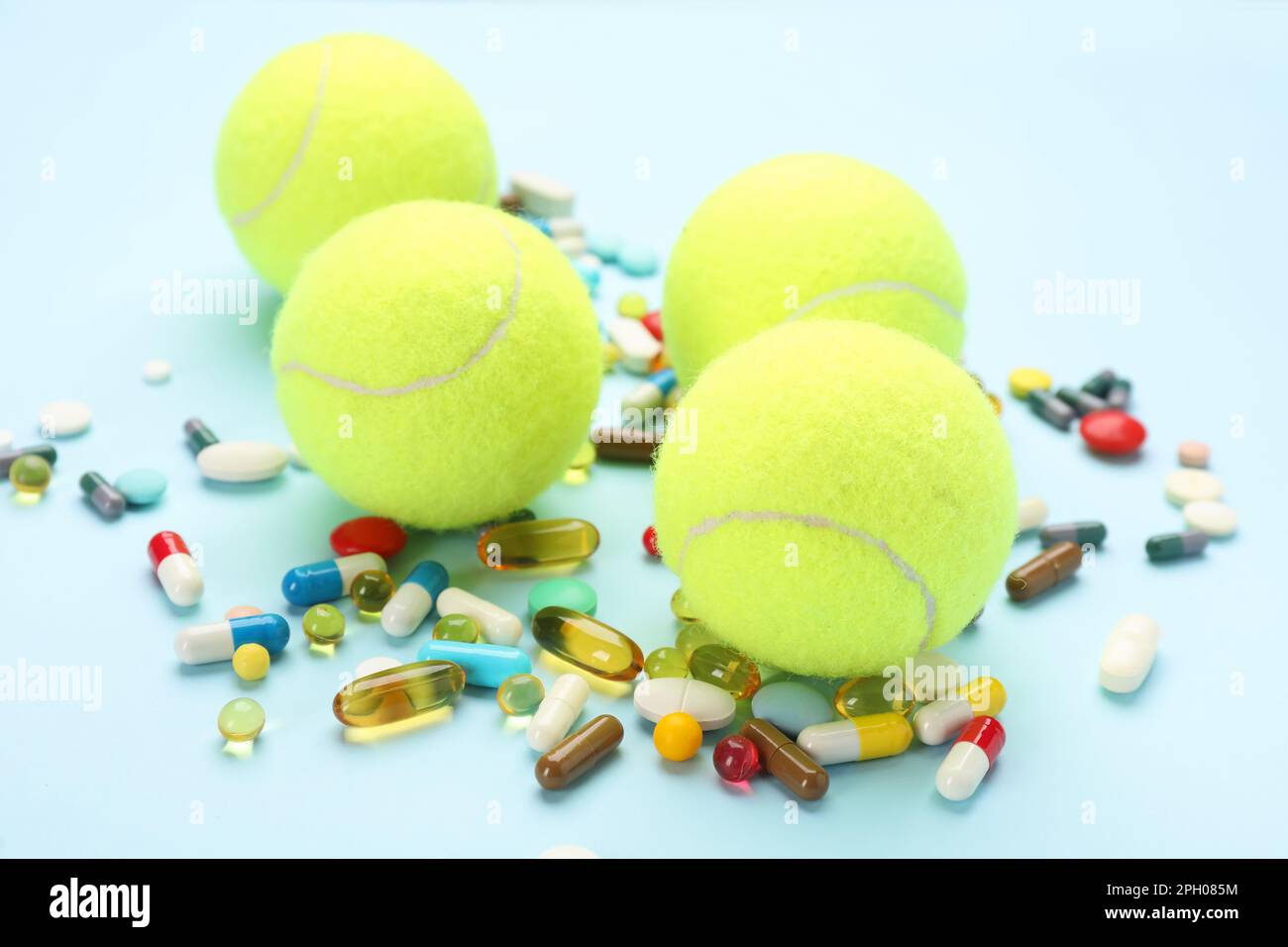 Tennis balls and different pills on light blue background. Doping ...