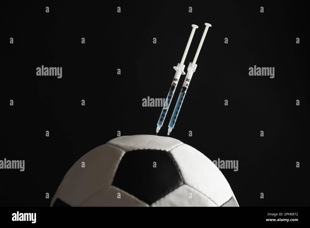 Soccer ball with syringes on black background, closeup. Doping concept ...