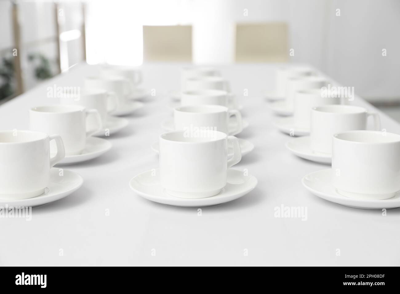 Many empty cups on white table indoors for coffee break Stock Photo - Alamy
