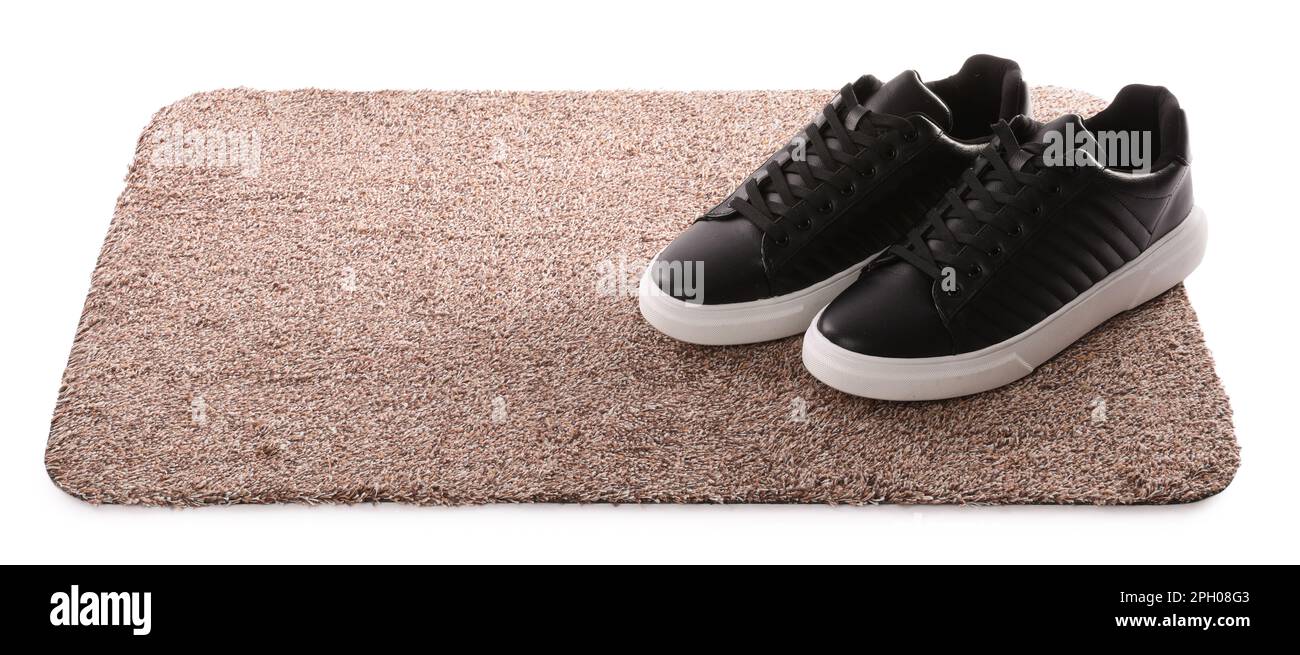 Stylish door mat with shoes on white background Stock Photo - Alamy
