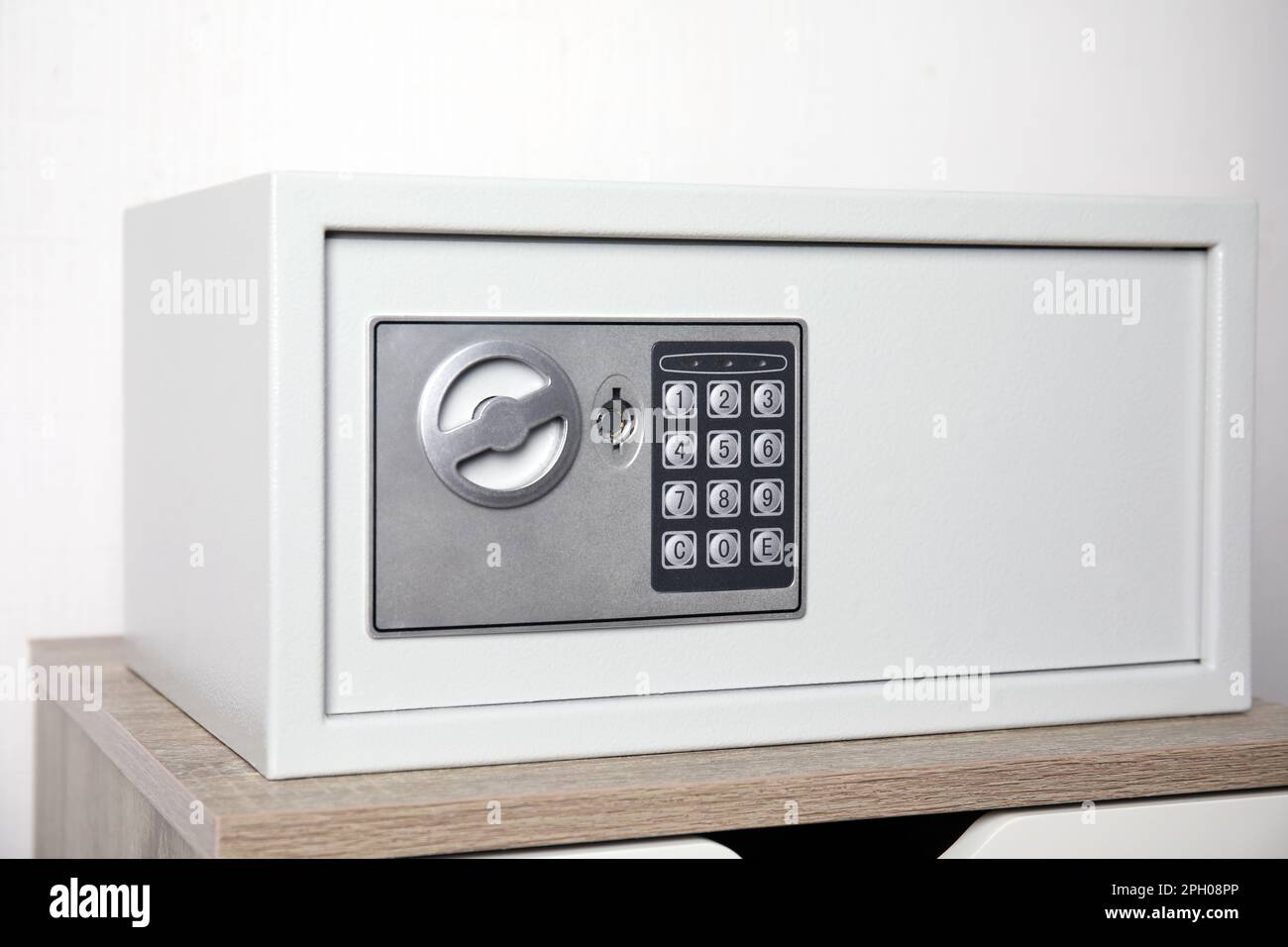 Closed steel safe on wooden table against white background Stock Photo ...