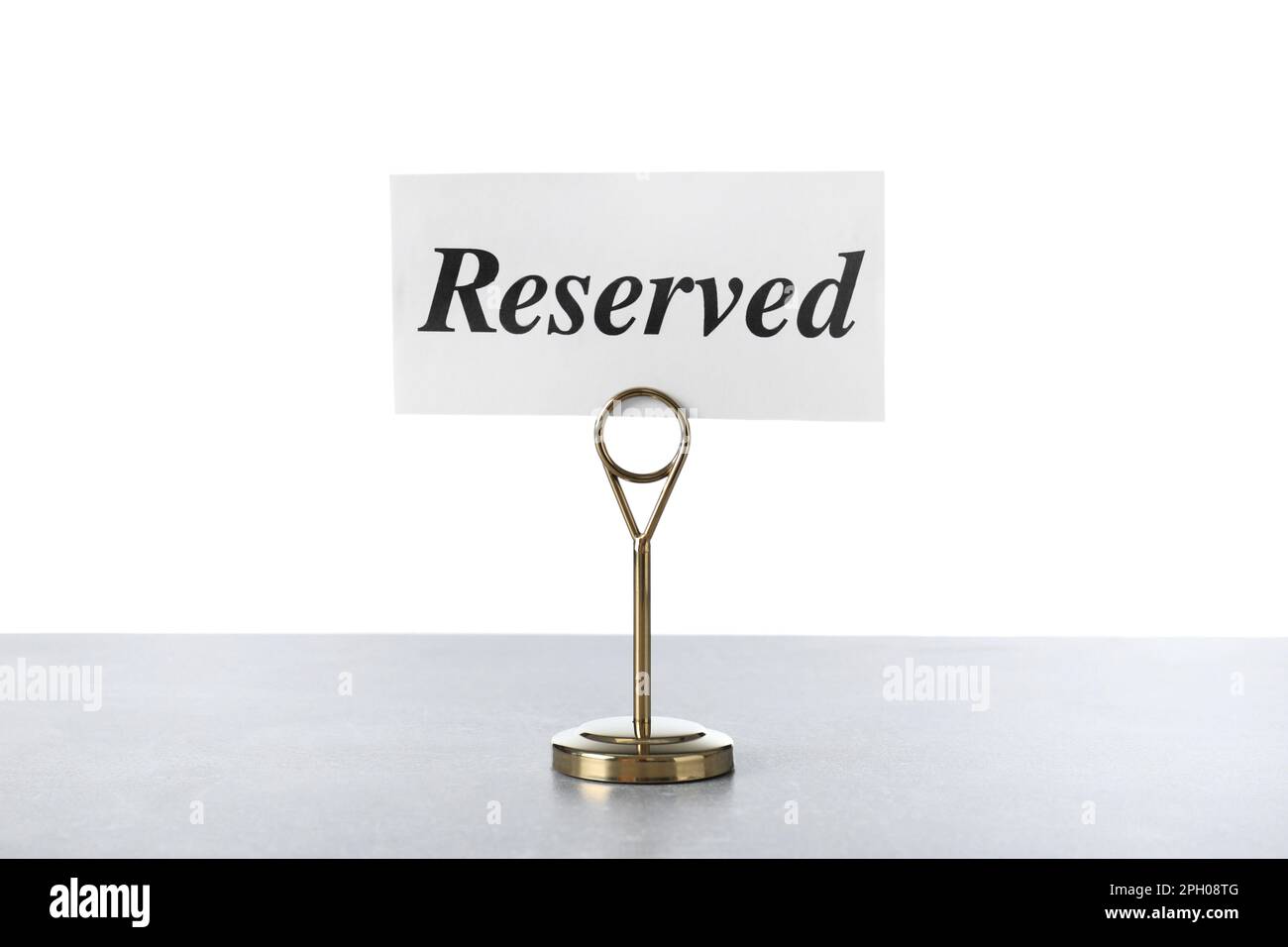 Elegant sign Reserved on light grey table against white background ...