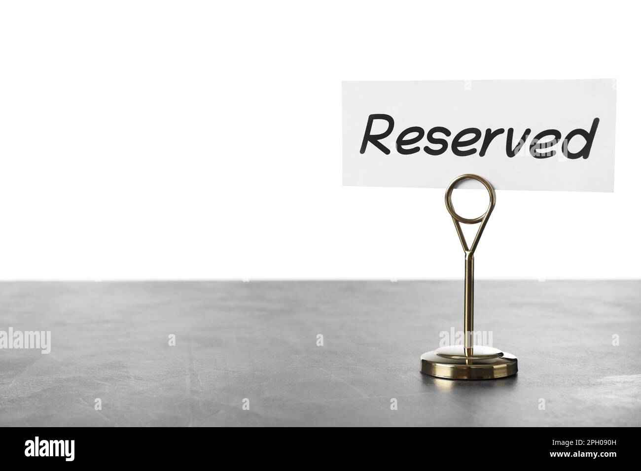 Elegant sign Reserved on grey table against white background, space for ...