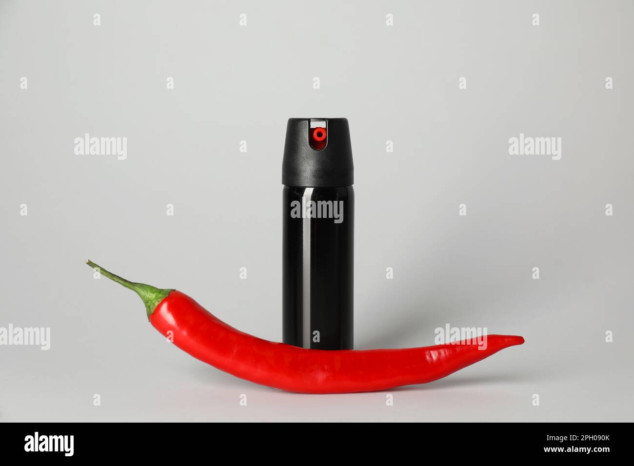 Bottle of gas spray and fresh chili pepper on grey background Stock ...