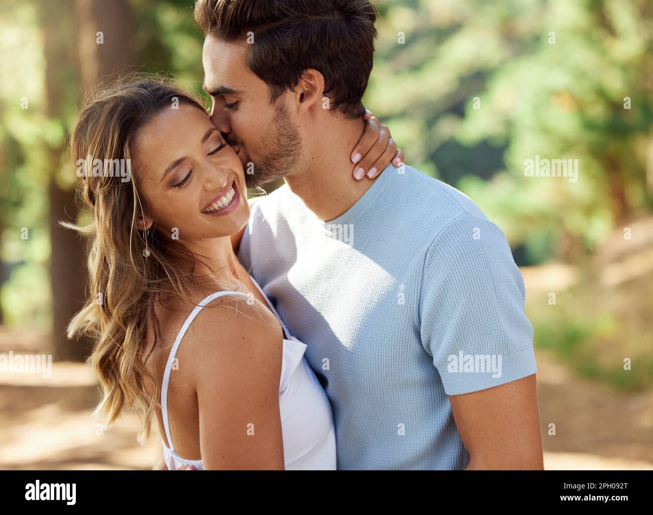 Couple, kiss on cheek and love with hug, summer with freedom and ...