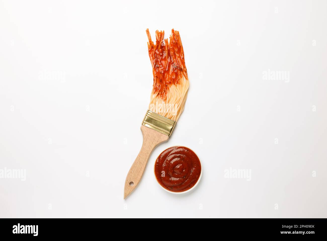 Brush painting with spaghetti dipped in ketchup on white background ...