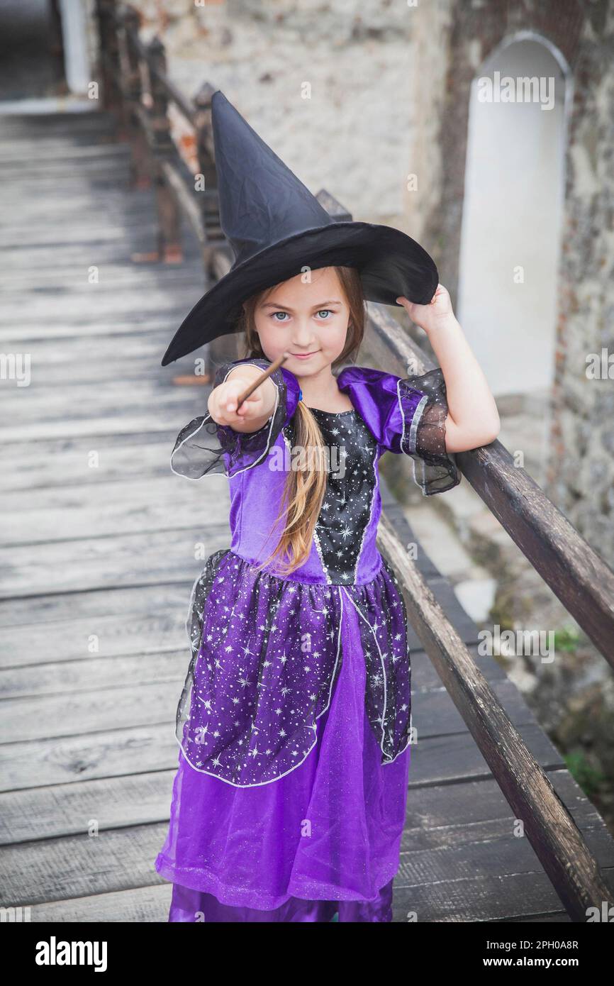 young sorceress on the bridge in the castle conjuring by magic wand ...