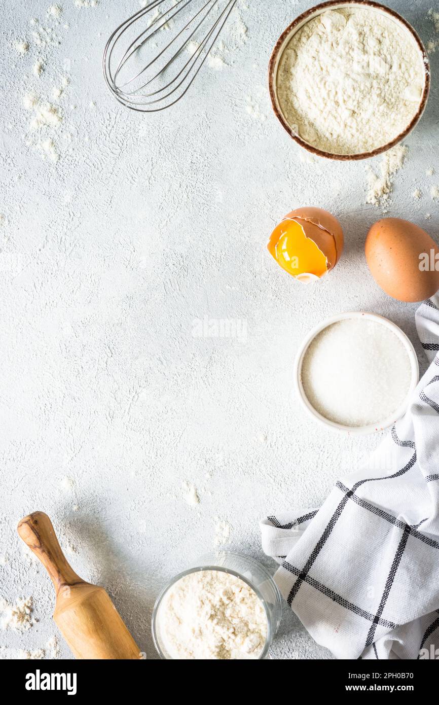 Baking background at light stone table. Flour, sugar, eggs and rolling ...
